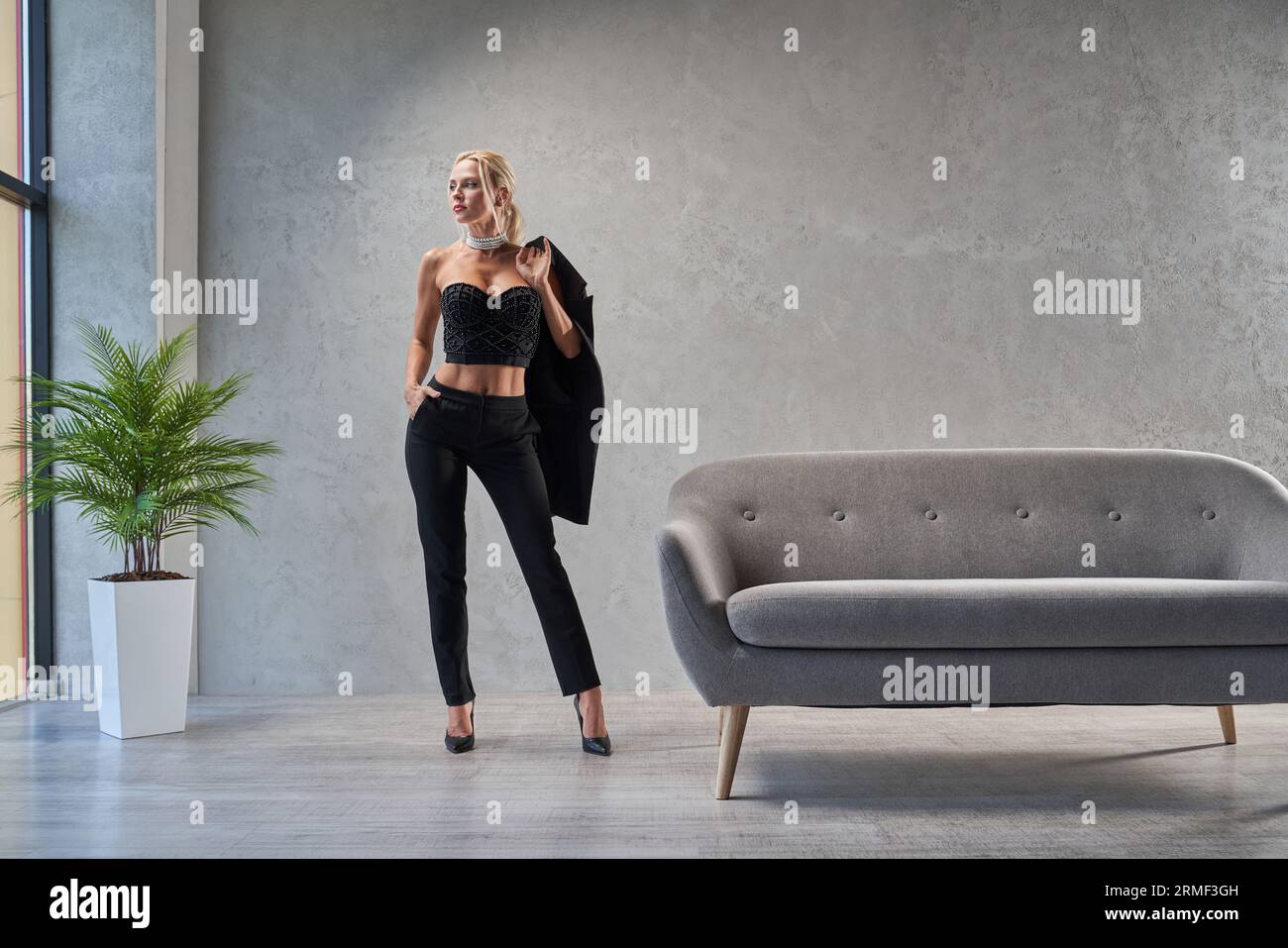 Beautiful caucasian fashion model posing in front of gray concrete wall ...