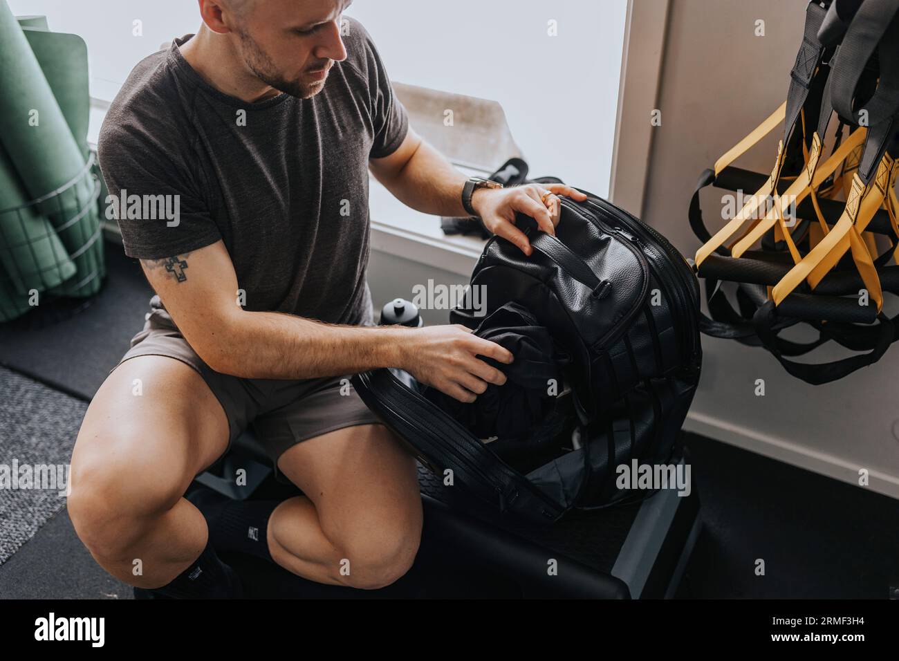 Man packing equipment after workout in gym Stock Photo - Alamy