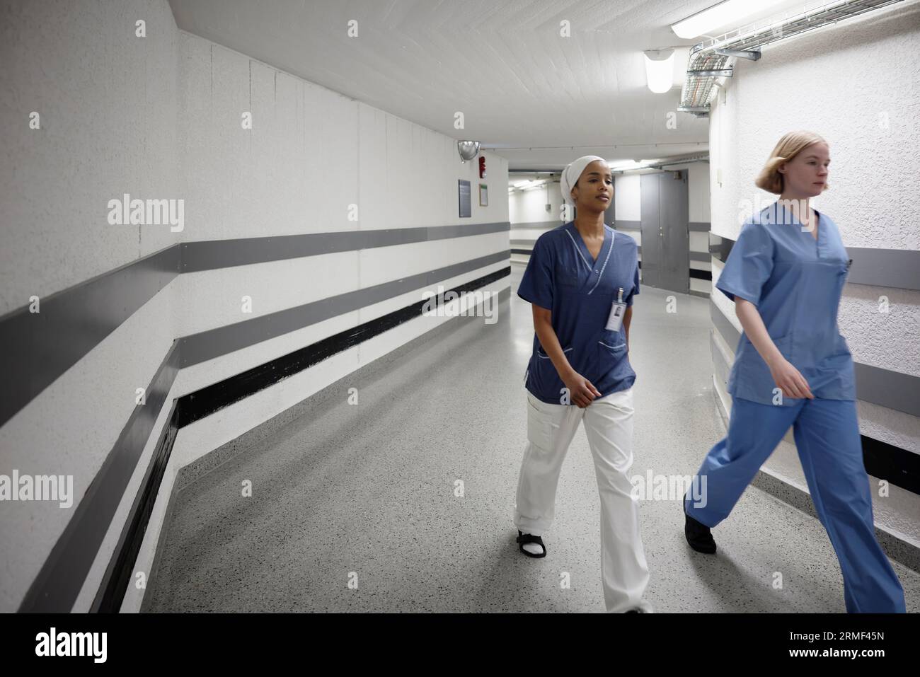Female doctors walking through hospital corridor Stock Photo - Alamy