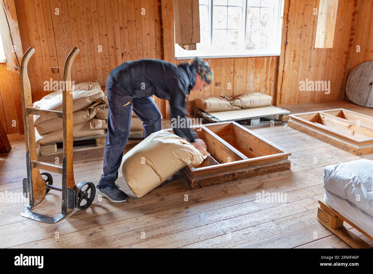 Woman in mill pouring flour from sack Stock Photo - Alamy