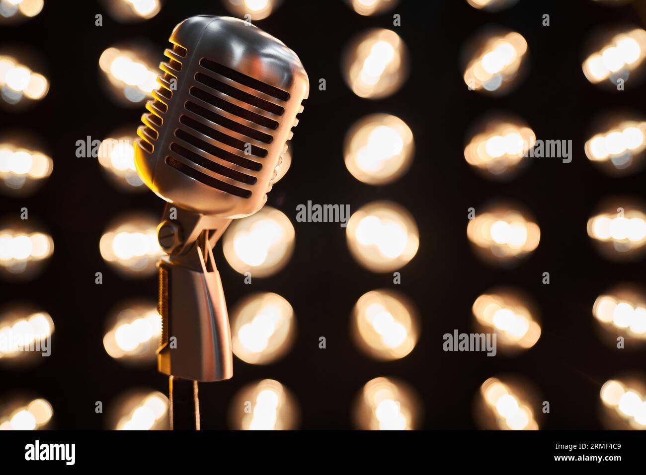 Metal mic with stand against dark sparkling bokeh backdrop. Close up of ...