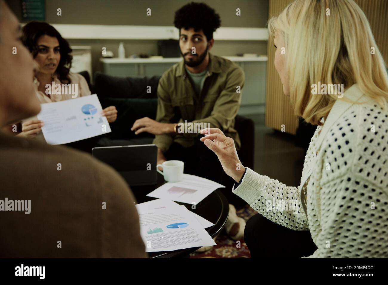 Group of business people analyzing charts during meeting in lobby Stock ...