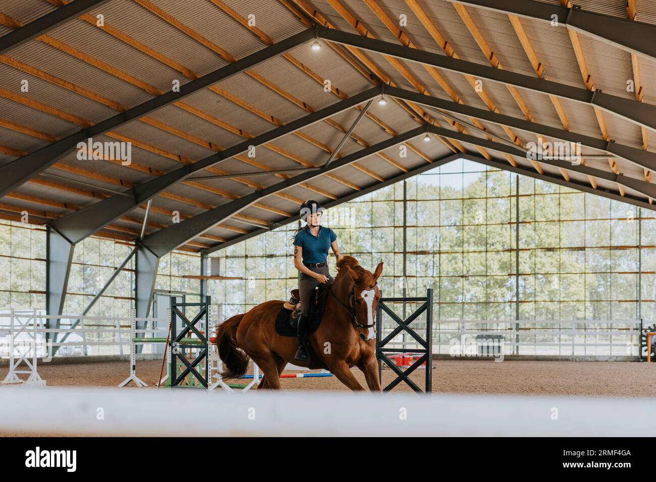 View of female horse rider using indoor riding paddock Stock Photo - Alamy