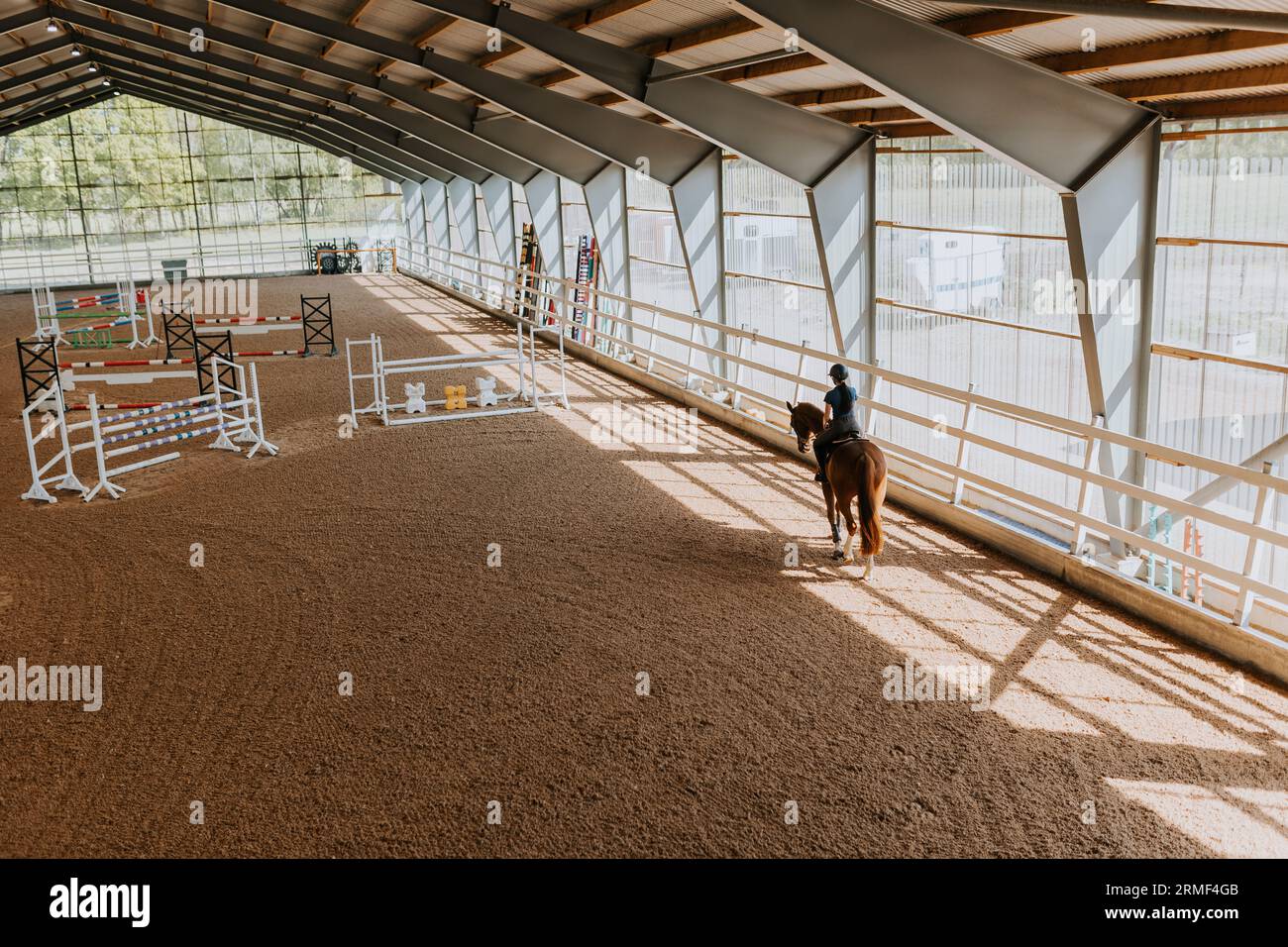 View of horse rider using indoor riding paddock Stock Photo - Alamy