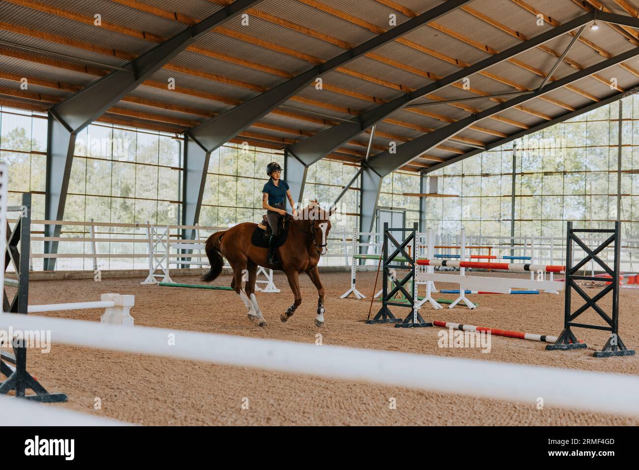 View of female horse rider using indoor riding paddock Stock Photo - Alamy
