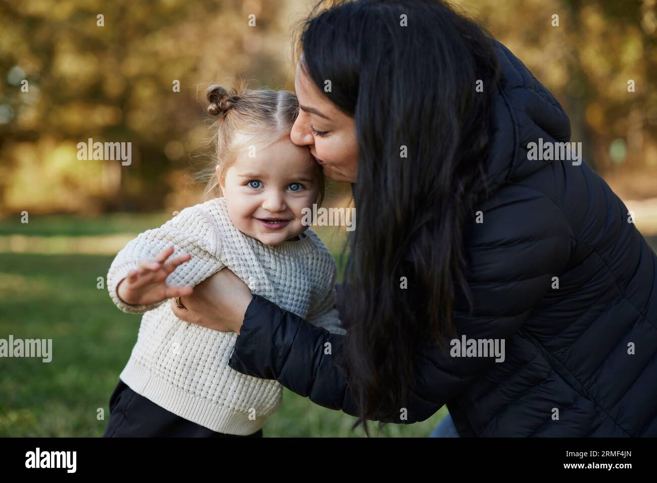 Happy mother hugging daughter in park Stock Photo - Alamy