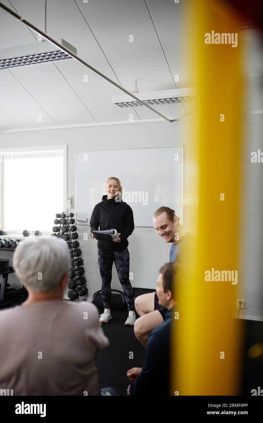 Smiling people talking together in gym Stock Photo - Alamy