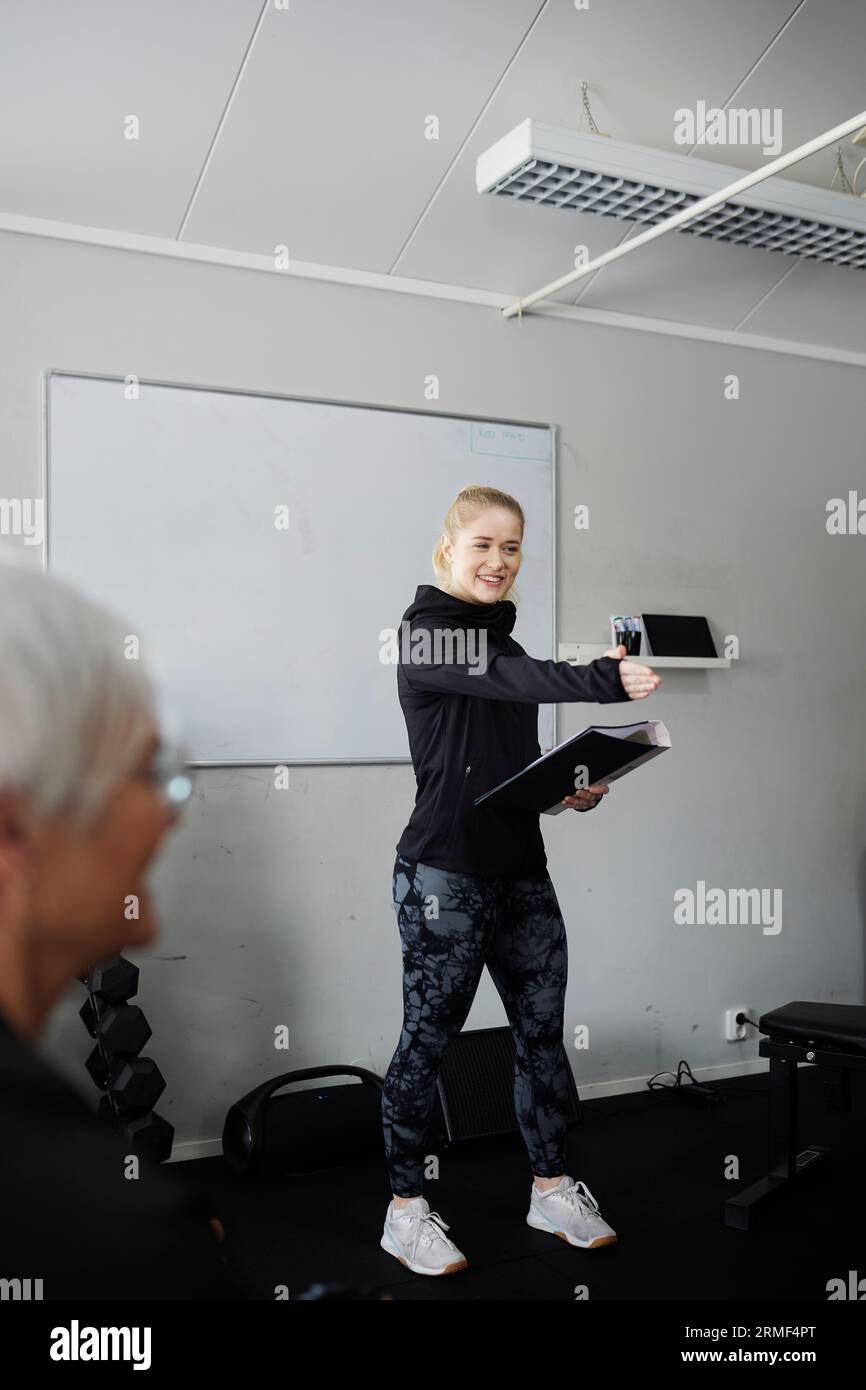 Female coach during presentation in gym Stock Photo - Alamy
