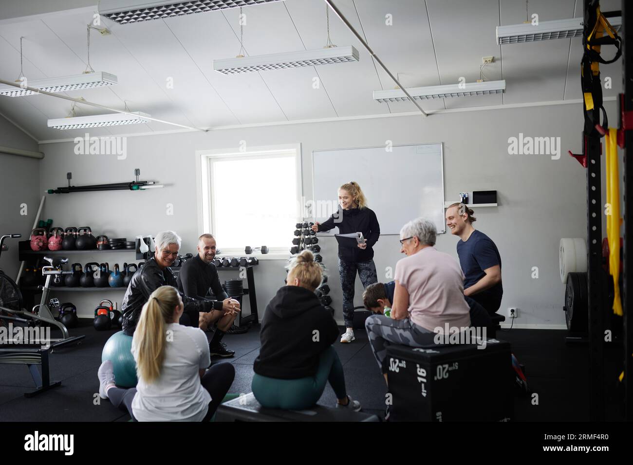 Smiling people talking together in gym Stock Photo - Alamy