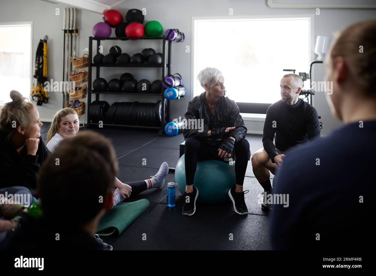 Smiling people talking together in gym Stock Photo - Alamy