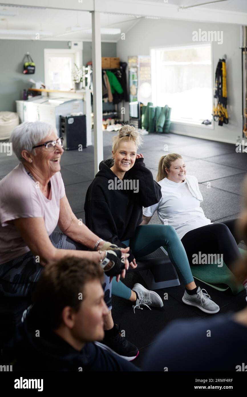 Smiling people talking together in gym Stock Photo - Alamy