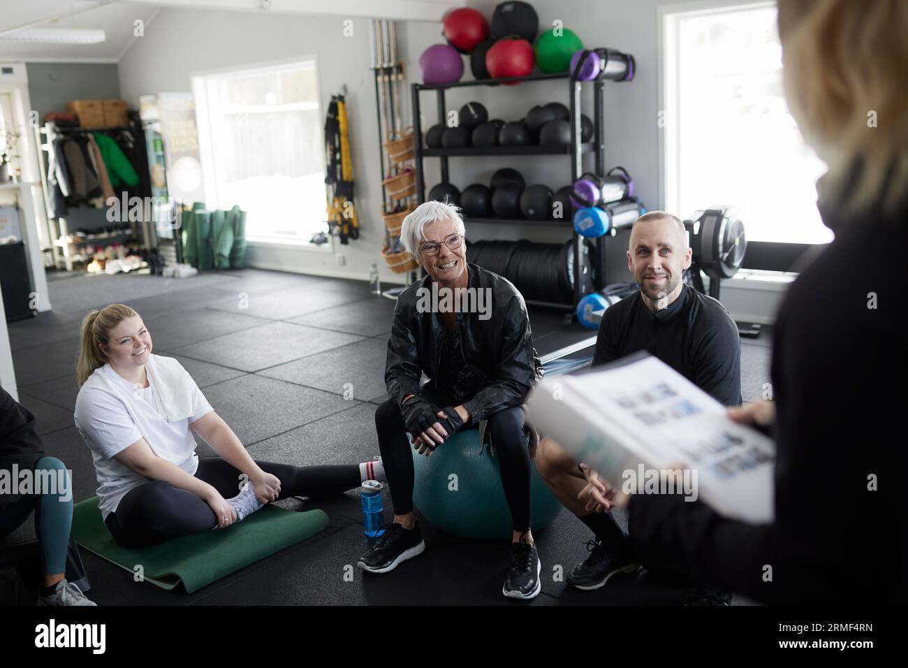 Smiling people talking together in gym Stock Photo - Alamy