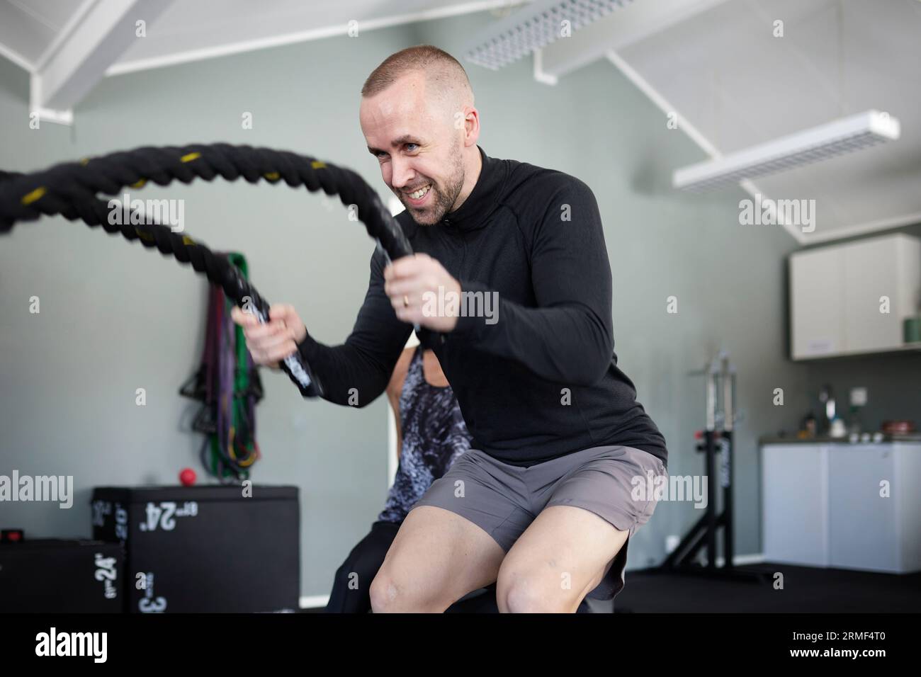 Man exercising with ropes in gym Stock Photo - Alamy