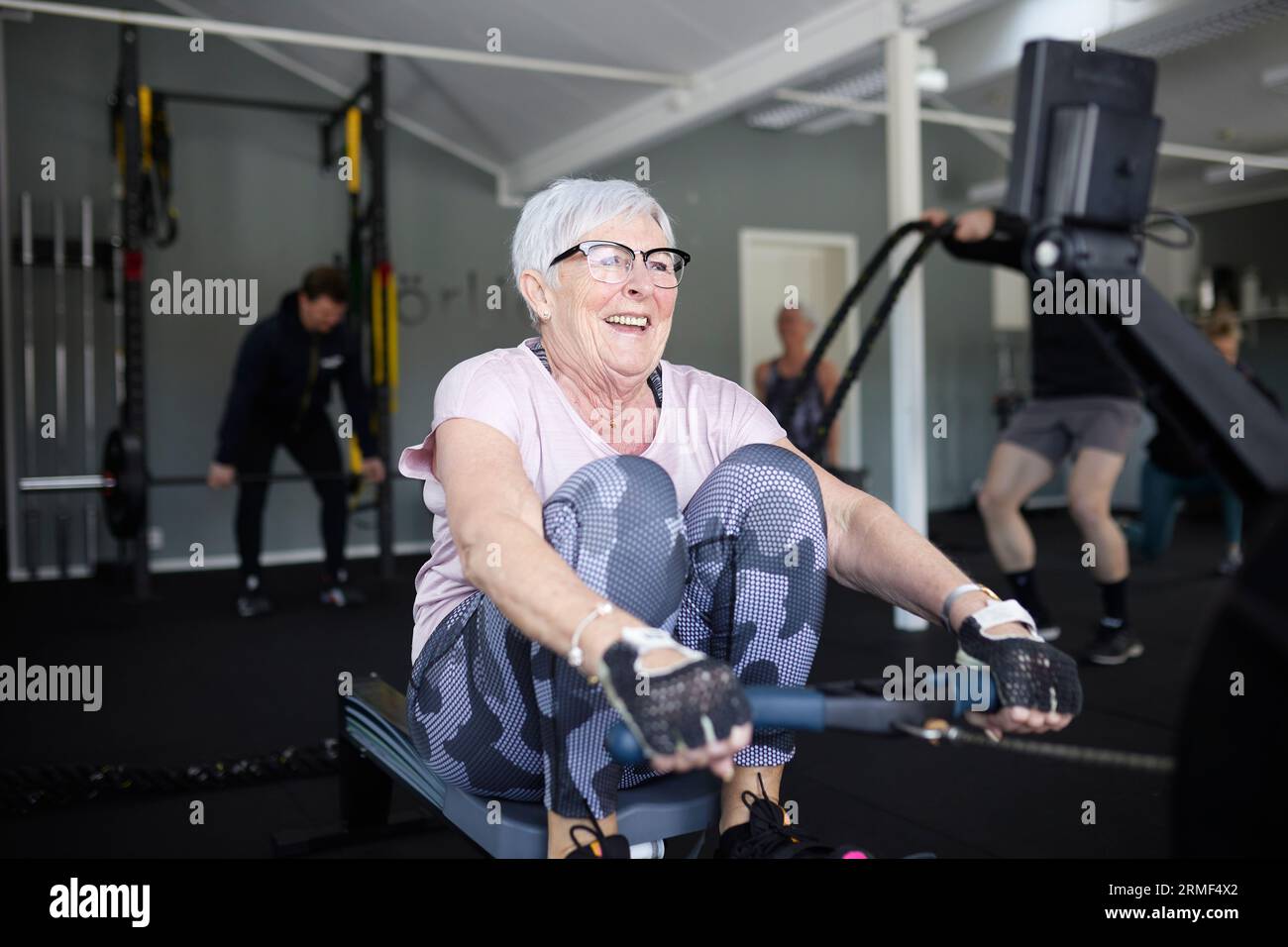 Smiling senior woman exercising in gym Stock Photo - Alamy