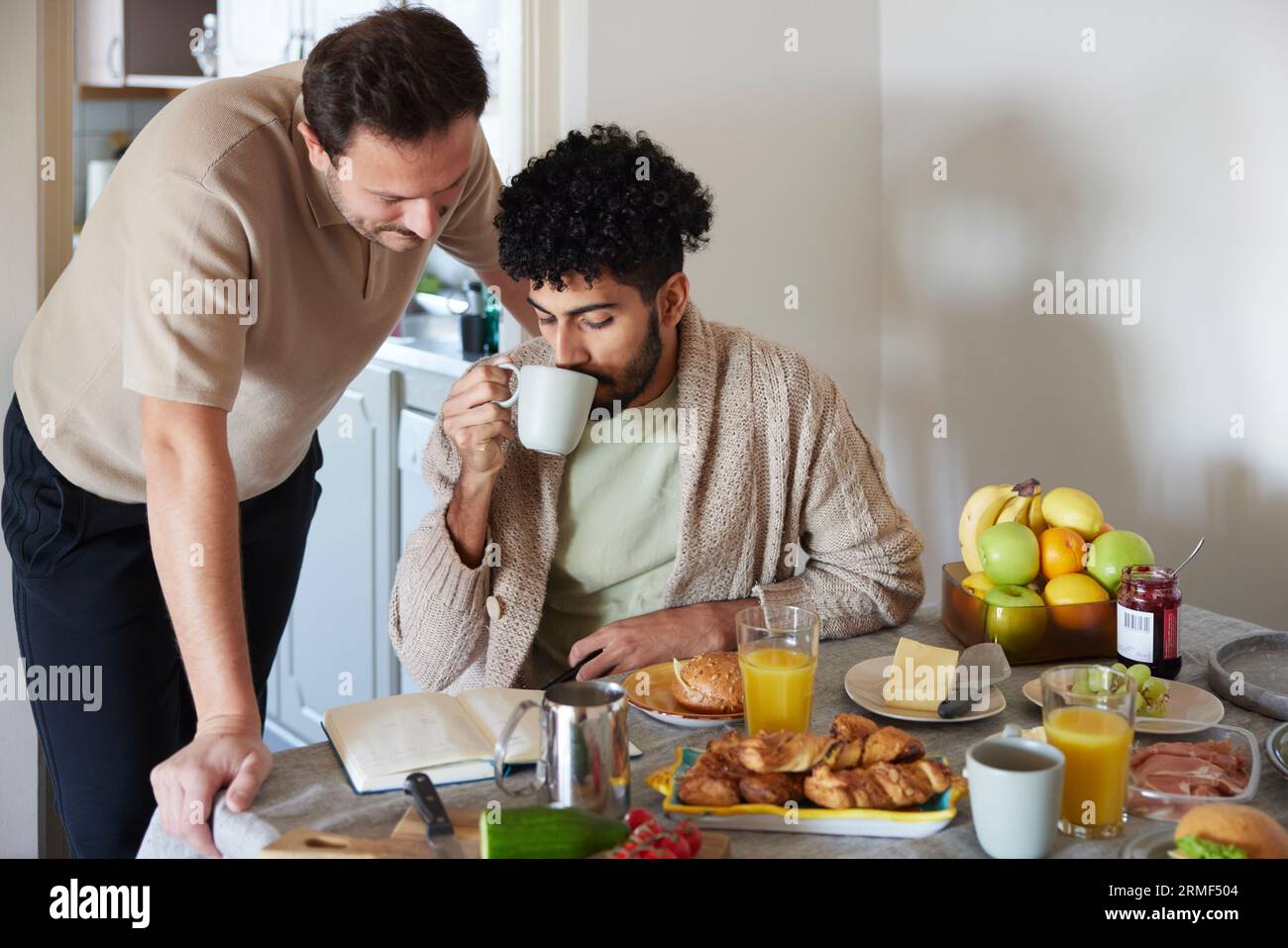 Happy gay couple eating breakfast at home Stock Photo - Alamy