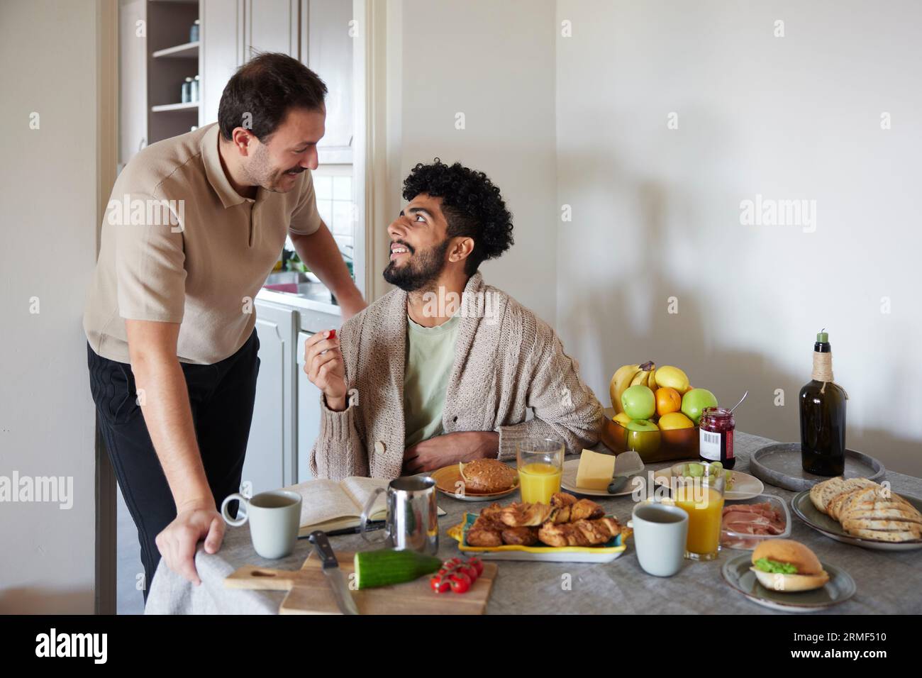 Happy gay couple eating breakfast at home Stock Photo - Alamy