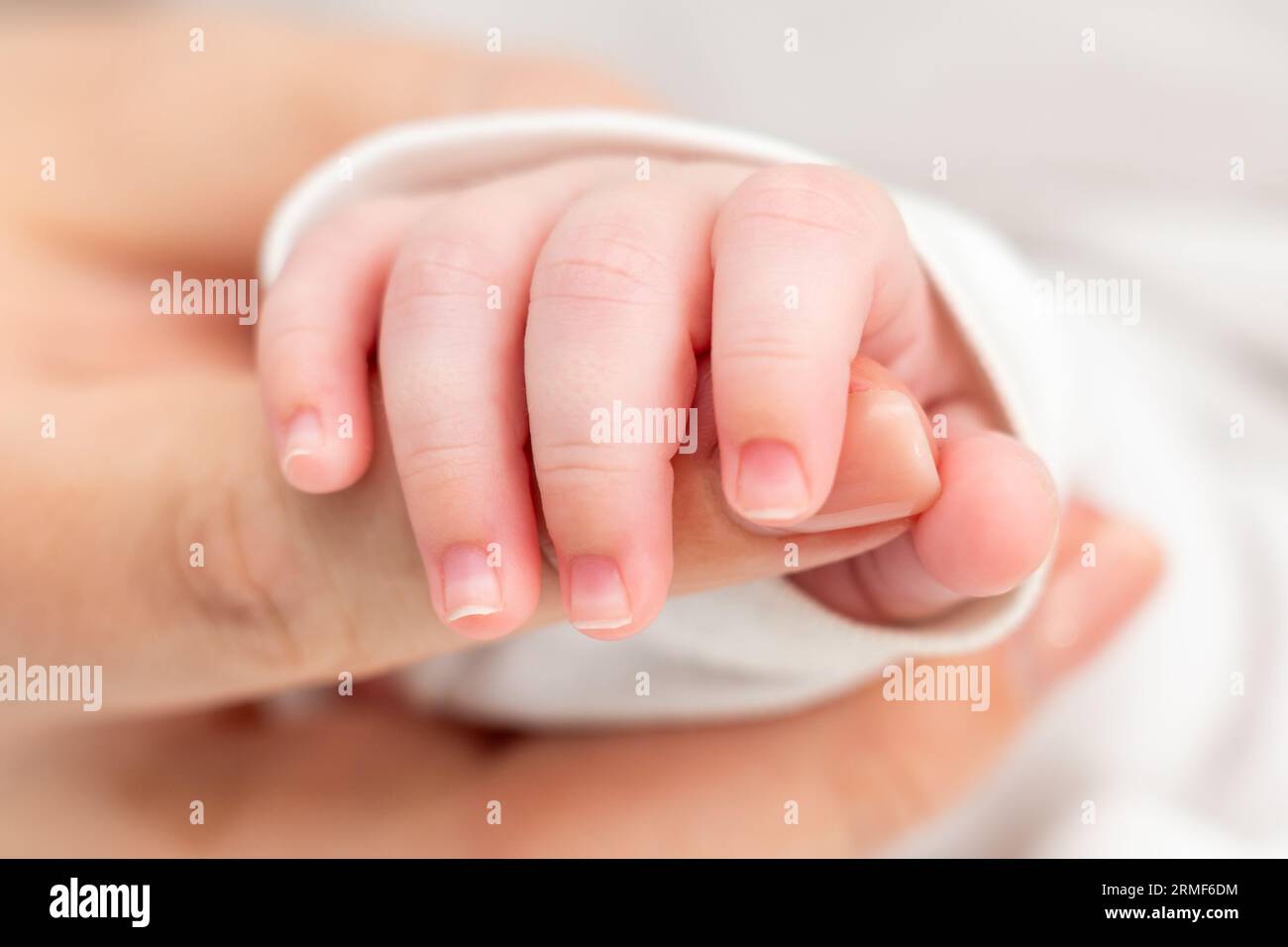 Innocence meets protection in newborn's grasp. Concept of mother-child ...