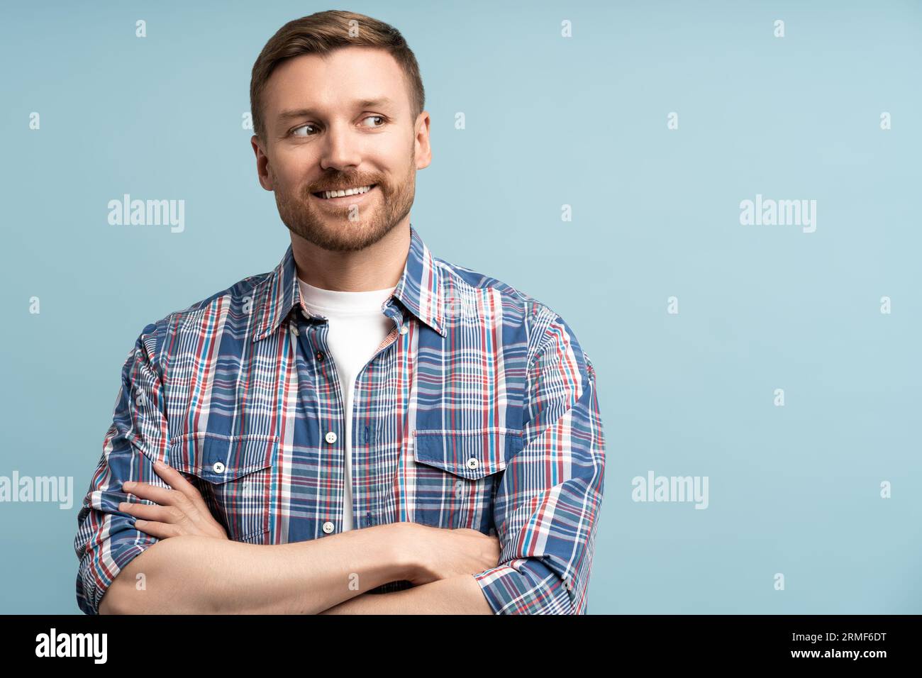 Positive pleased guy with crossed arms looks to side flirting enjoy ...