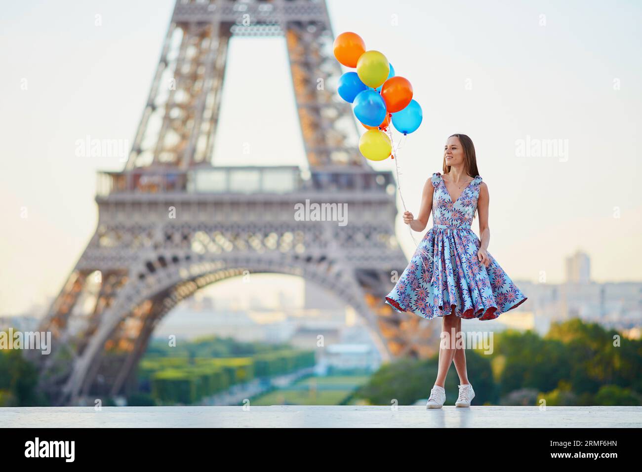 Beautiful young woman with bunch of colorful balloons dancing near the ...