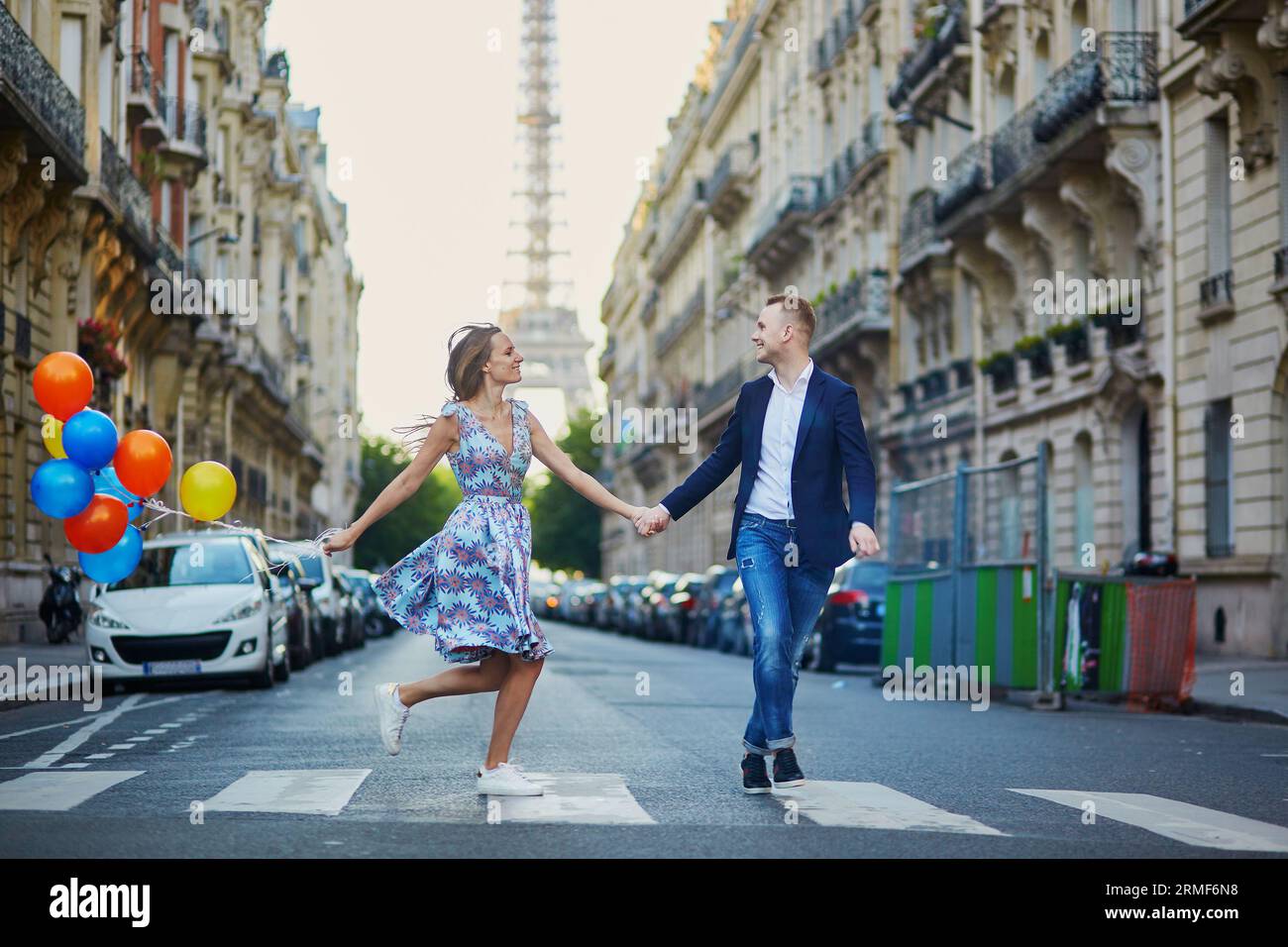 Romantic couple running across the street with Eiffel tower in ...