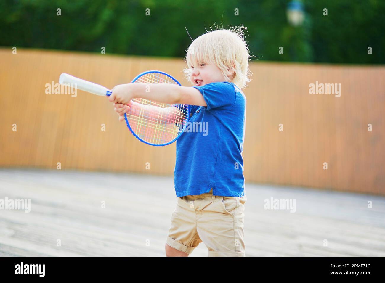 Adorable little boy playing badminton on the playground. Outdoor summer ...
