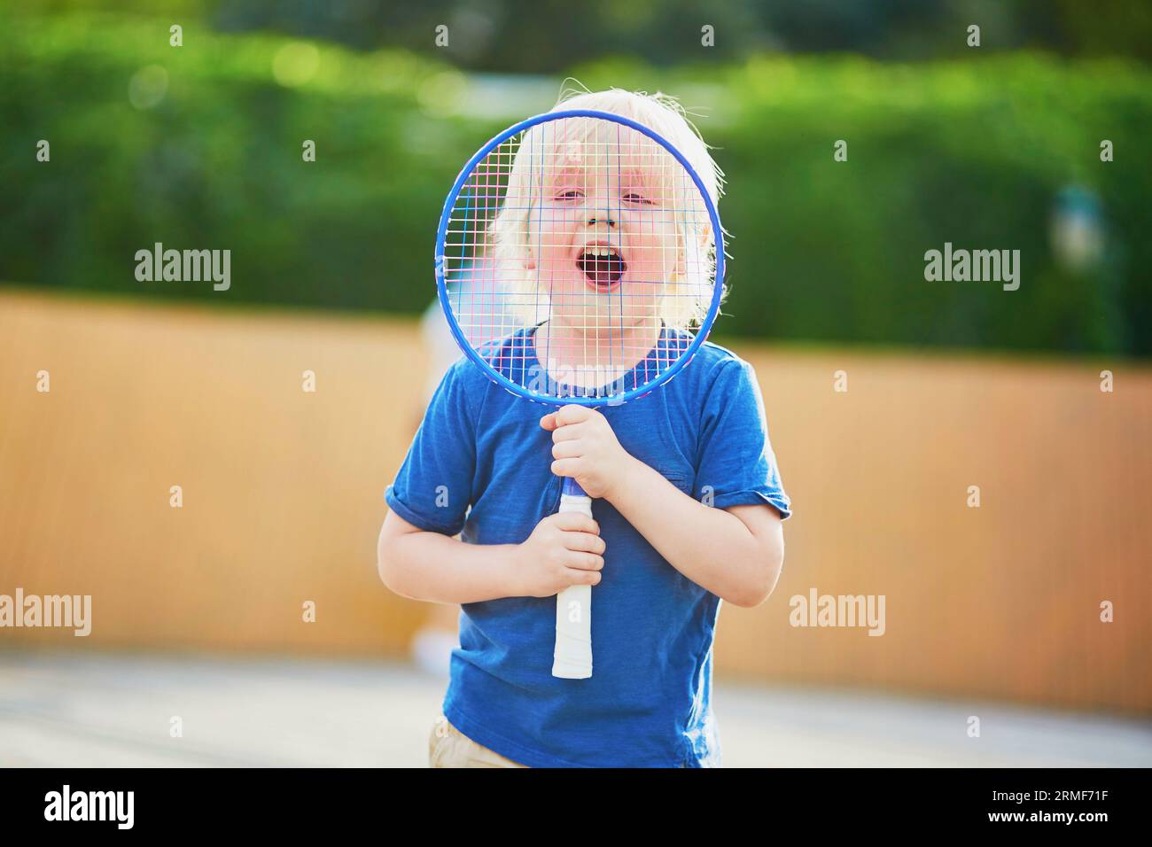 Adorable little boy playing badminton on the playground. Outdoor summer ...
