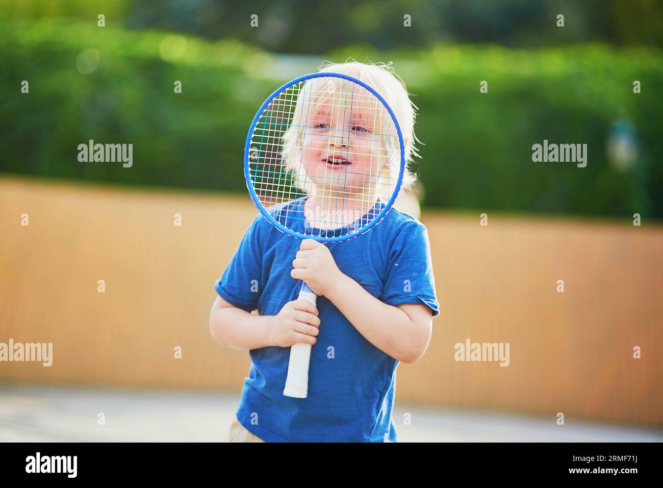 Adorable little boy playing badminton on the playground. Outdoor summer ...