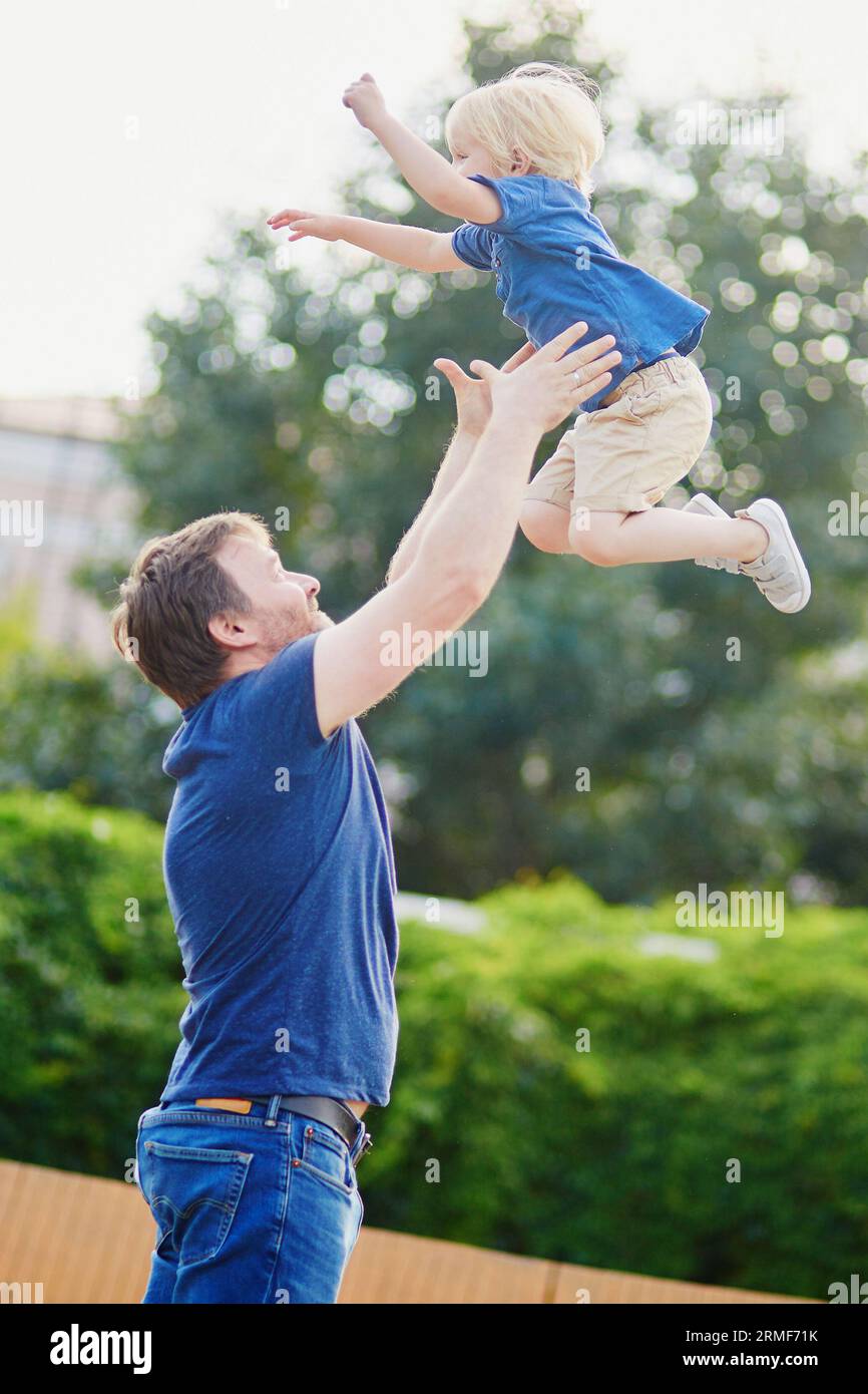 Father throwing his little son up in the air. Family time together ...