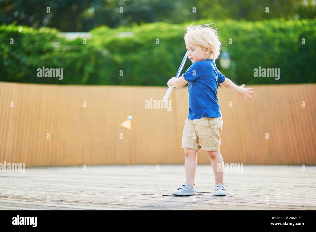 Adorable little boy playing badminton on the playground. Outdoor summer ...