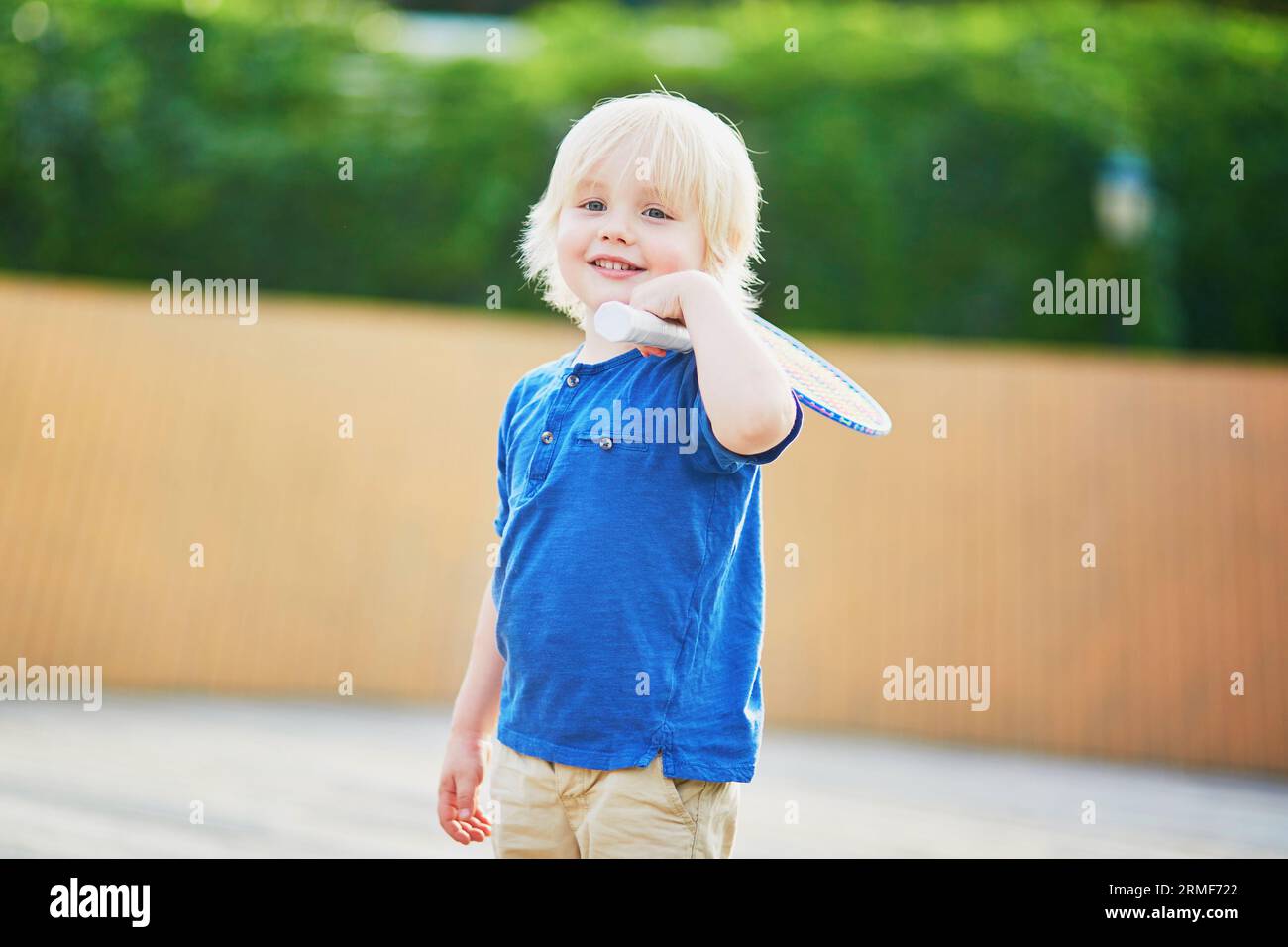 Adorable little boy playing badminton on the playground. Outdoor summer ...