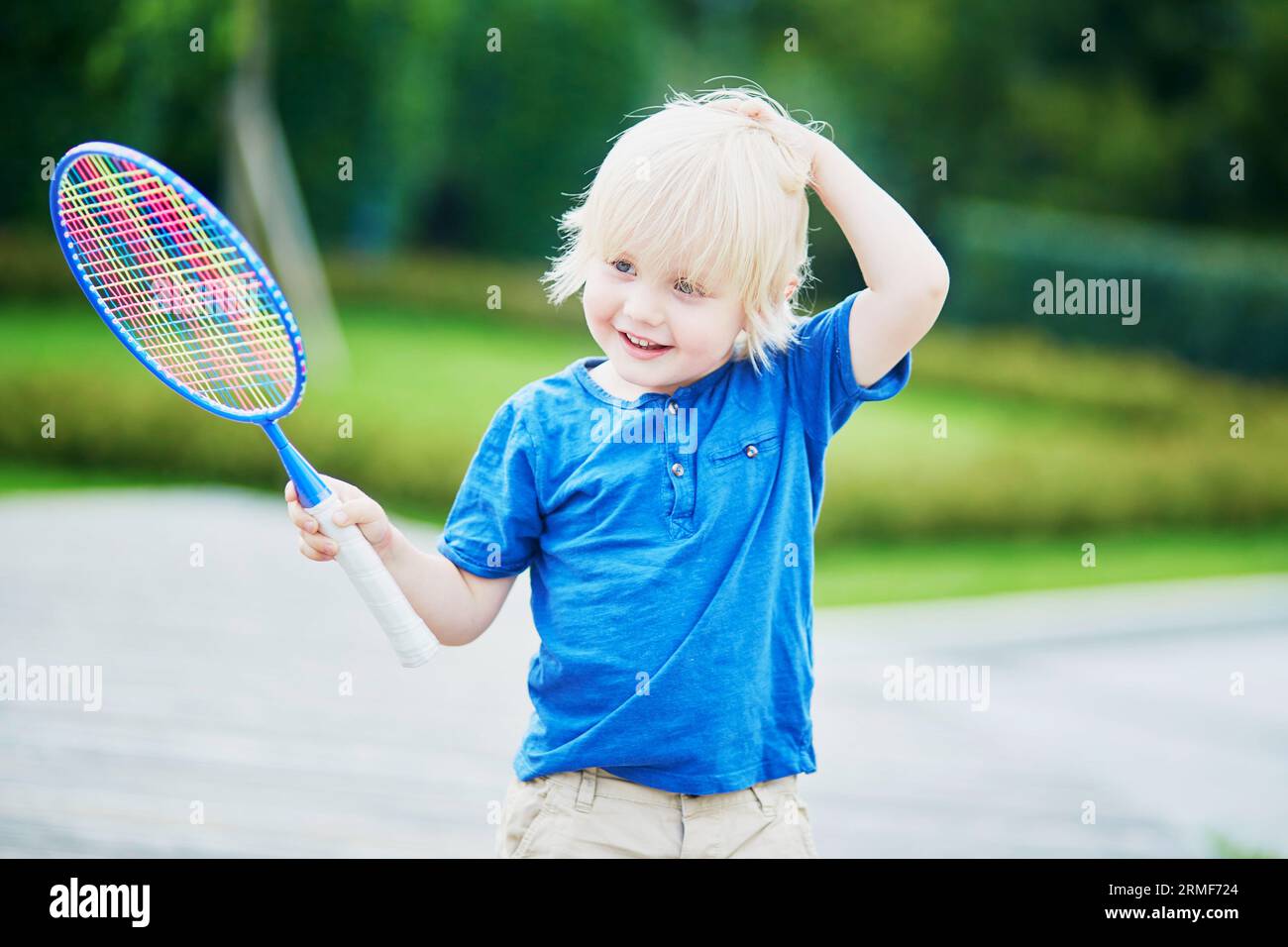 Adorable little boy playing badminton on the playground. Outdoor summer ...