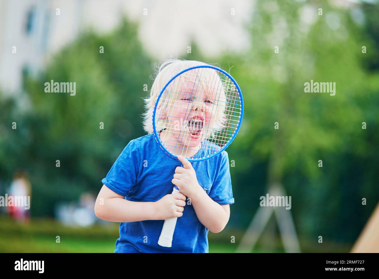 Adorable little boy playing badminton on the playground. Outdoor summer ...