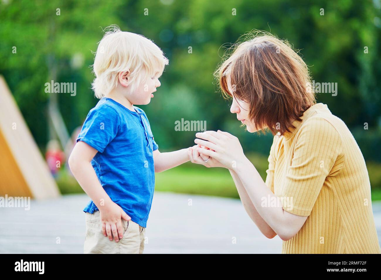 Mother comforting her crying son after he injured his hand Stock Photo ...