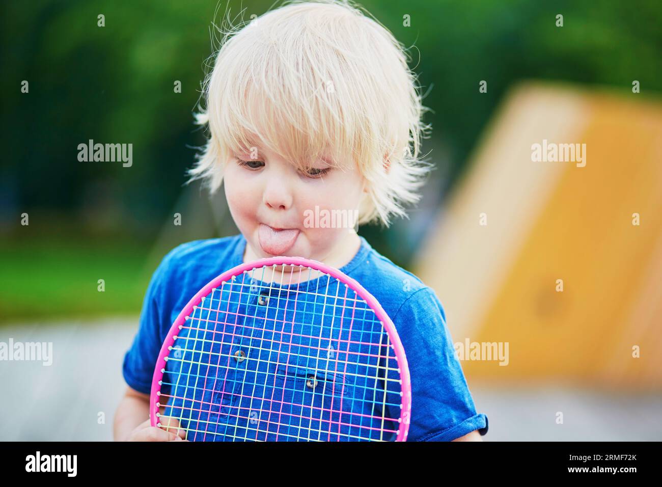 Adorable little boy playing badminton with his mother on the playground ...