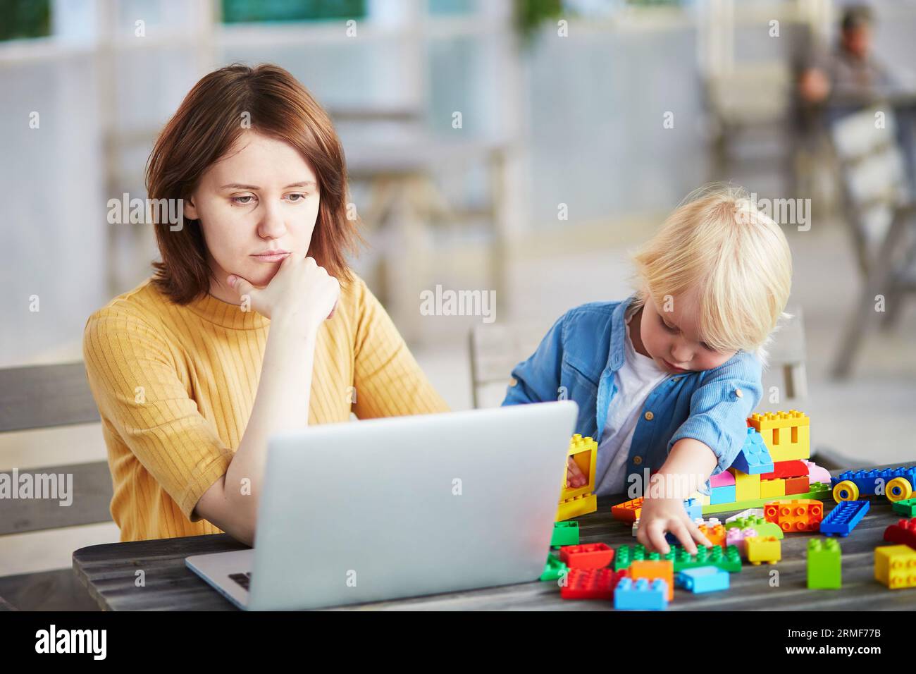 Adorable little boy playing with colorful plastic construction blocks ...