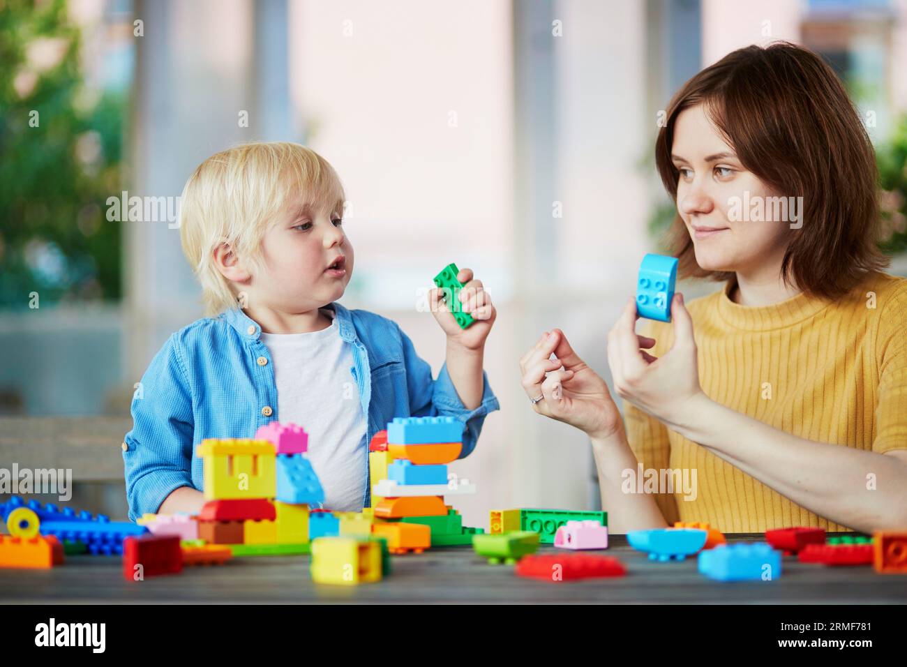 Young mother playing colorful construction blocks with her son. Quality ...
