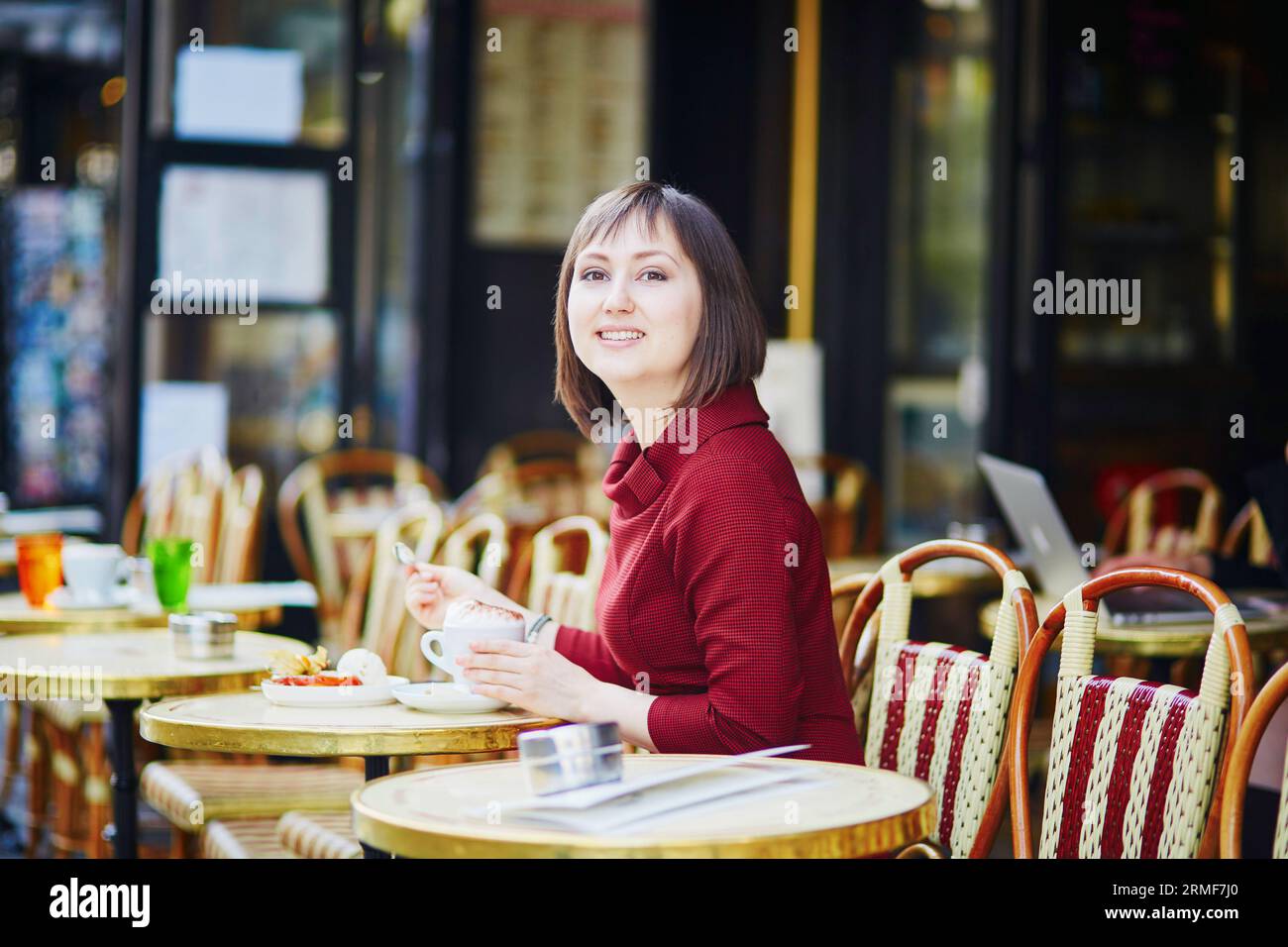 Beautiful French woman drinking coffee in outdoor cafe in Paris, France ...