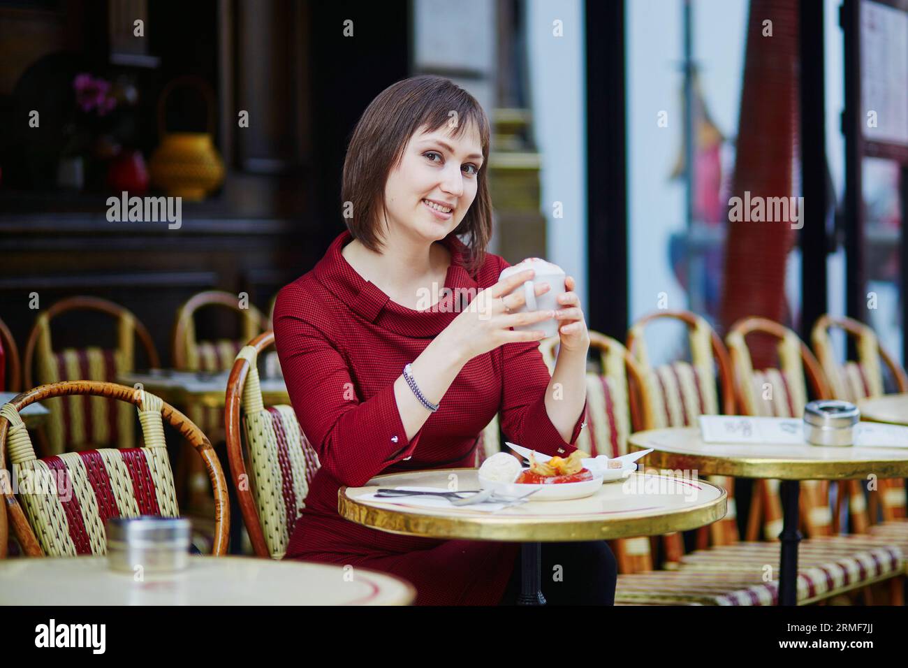 Beautiful young French woman drinking coffee in traditional Parisian ...