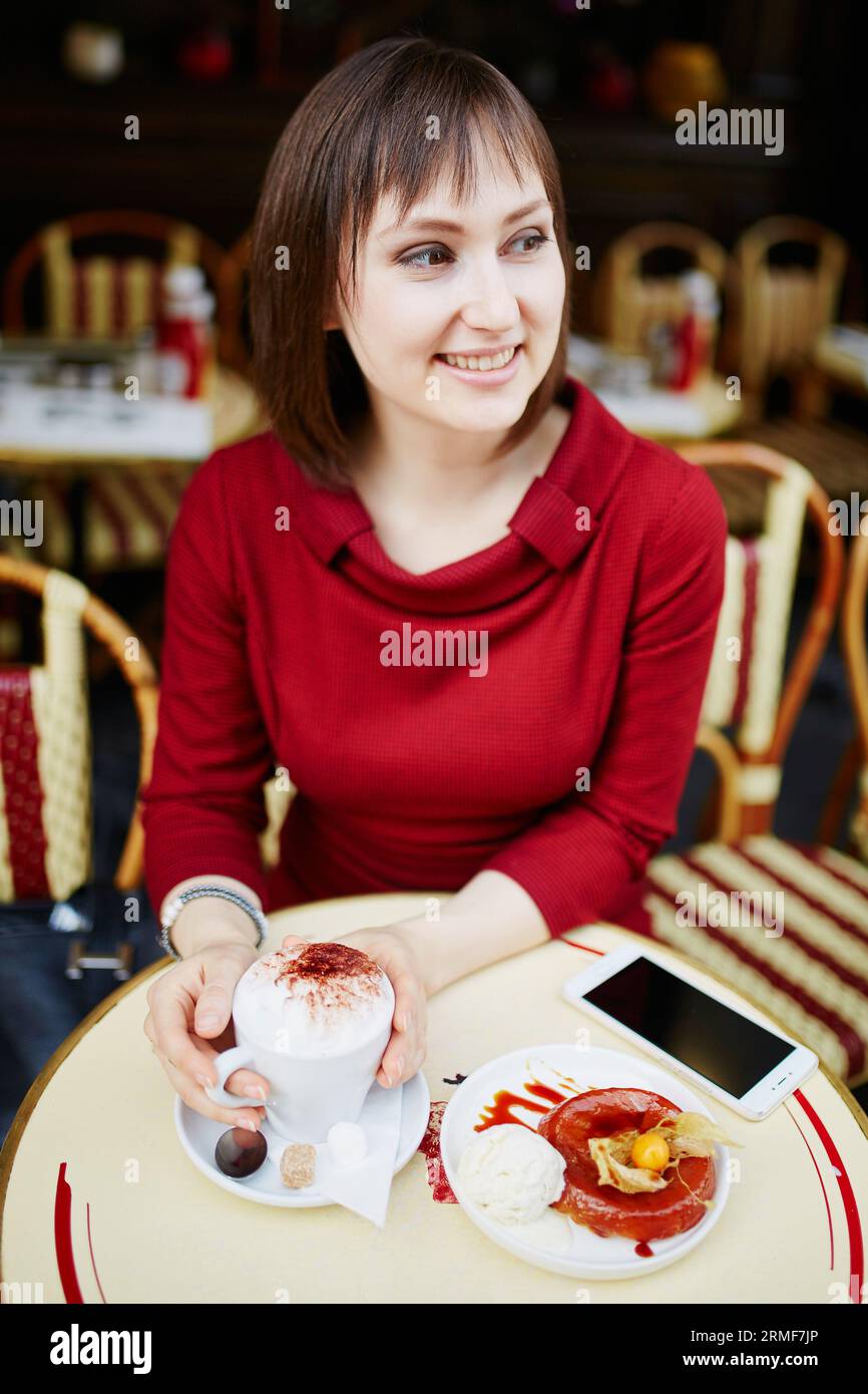 Beautiful young French woman drinking coffee in traditional Parisian ...