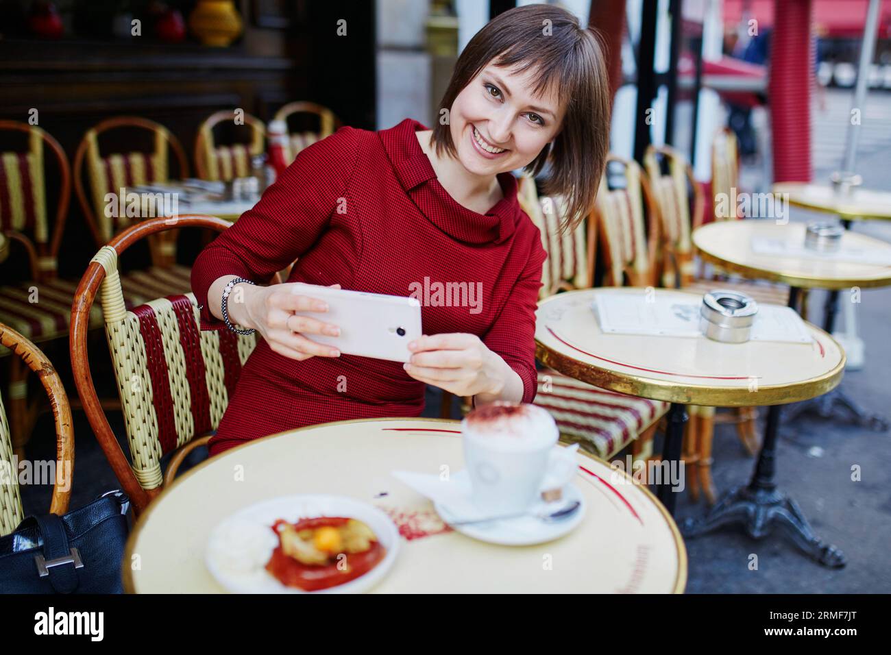 Beautiful young French woman drinking coffee in traditional Parisian ...