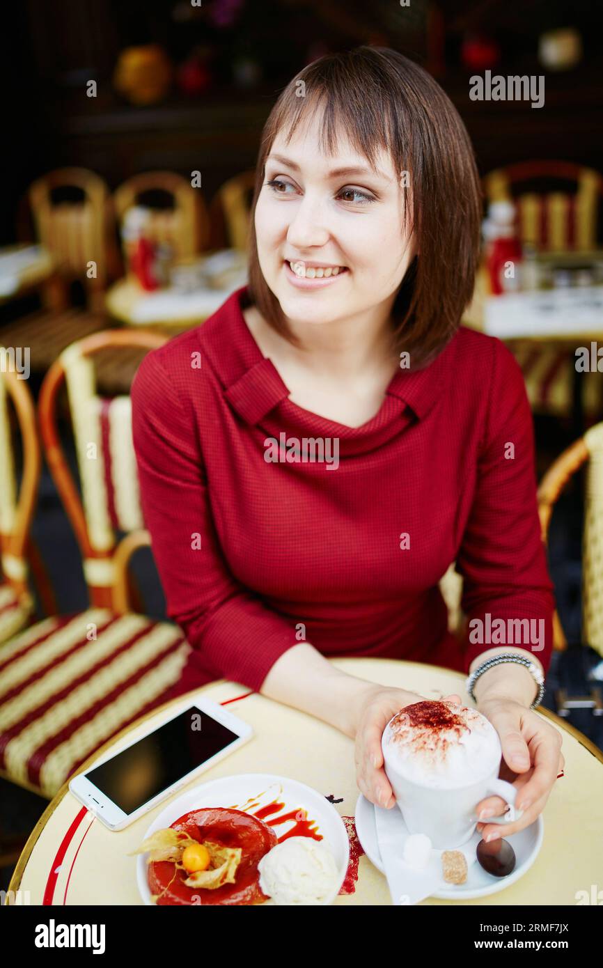 Beautiful French woman drinking coffee in outdoor cafe in Paris, France ...