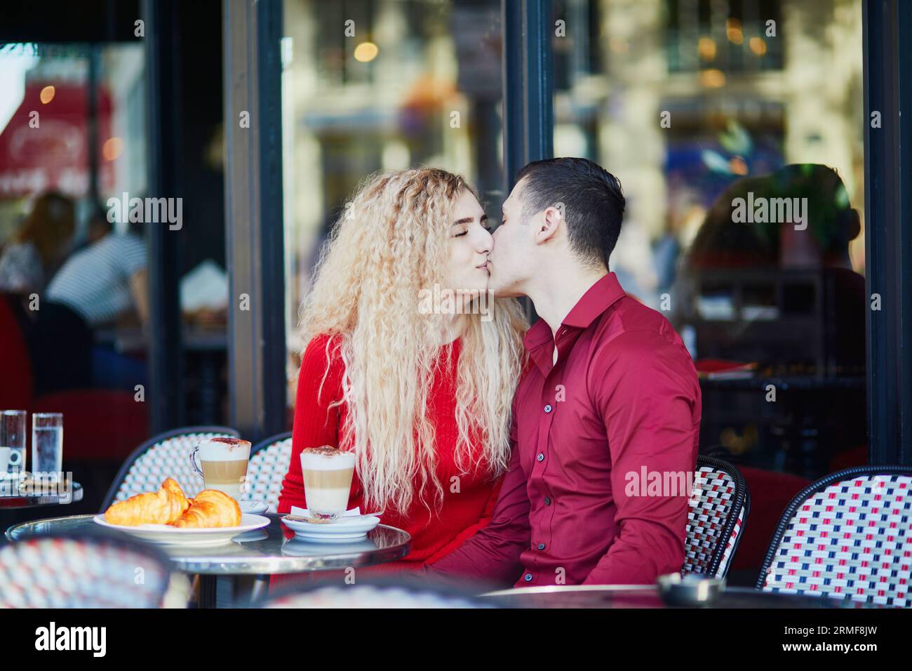 Beautiful romantic couple in Parisian outdoor cafe. Tourists drinking ...
