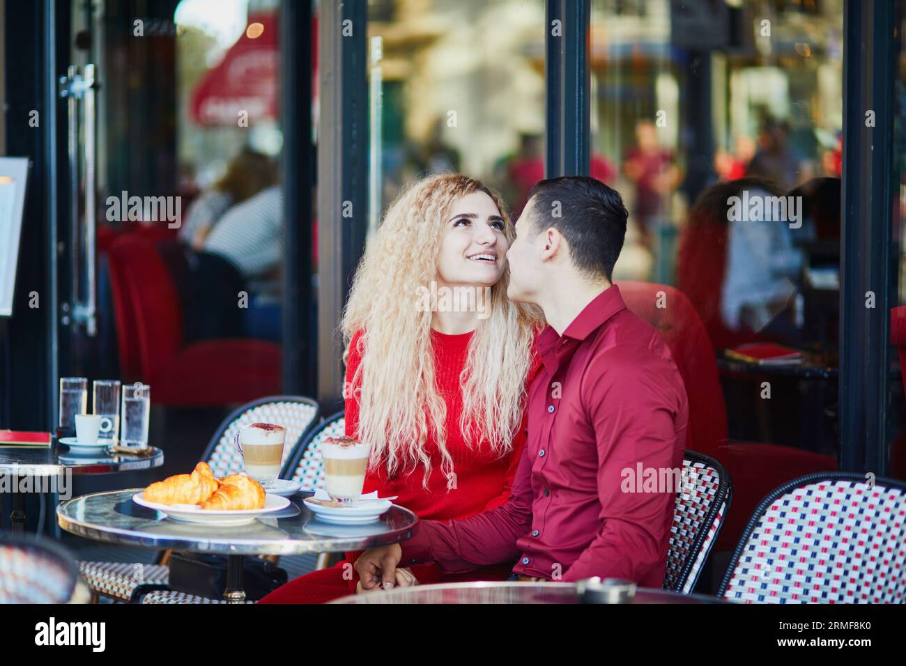 Beautiful romantic couple in Parisian outdoor cafe. Tourists drinking ...