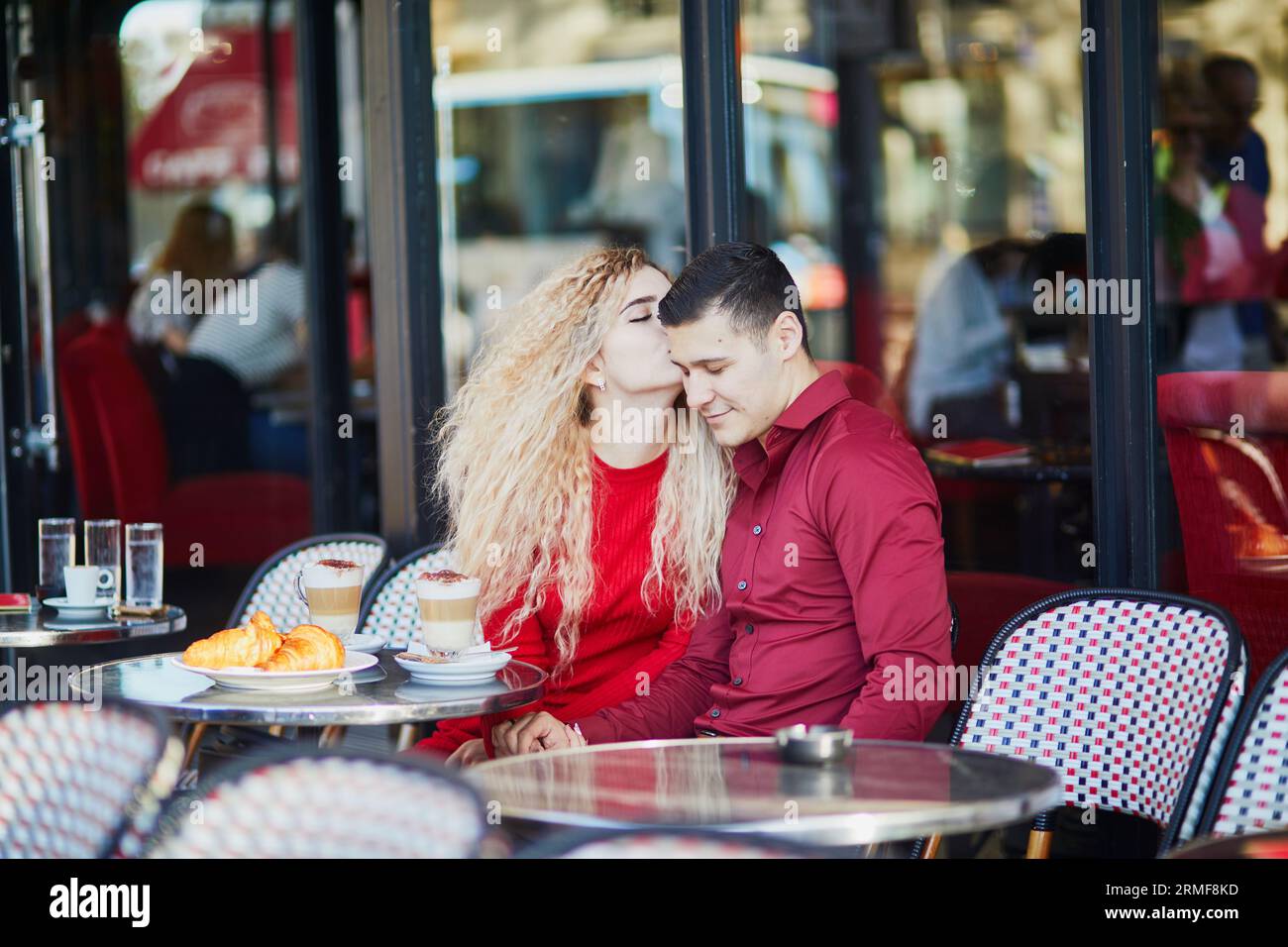 Beautiful romantic couple in Parisian outdoor cafe. Tourists drinking ...