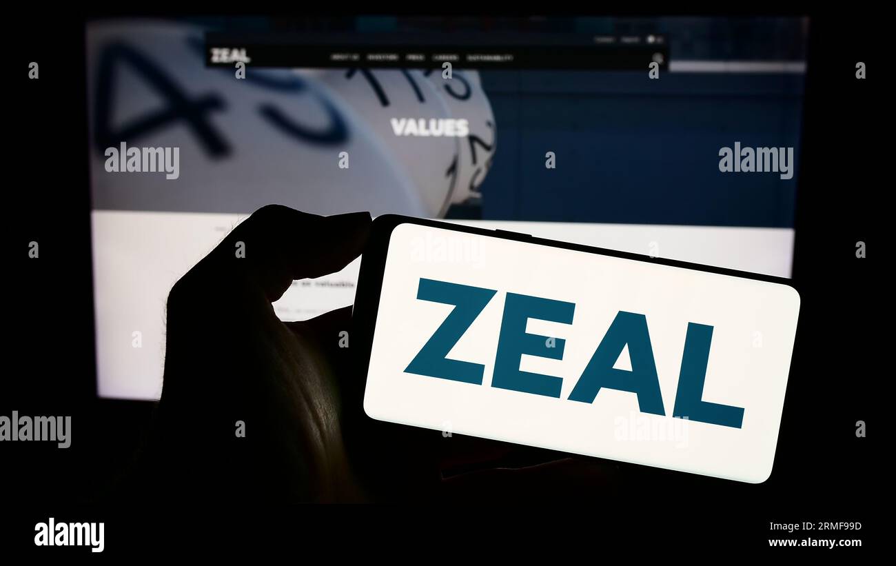Person holding smartphone with logo of German lottery company ZEAL ...