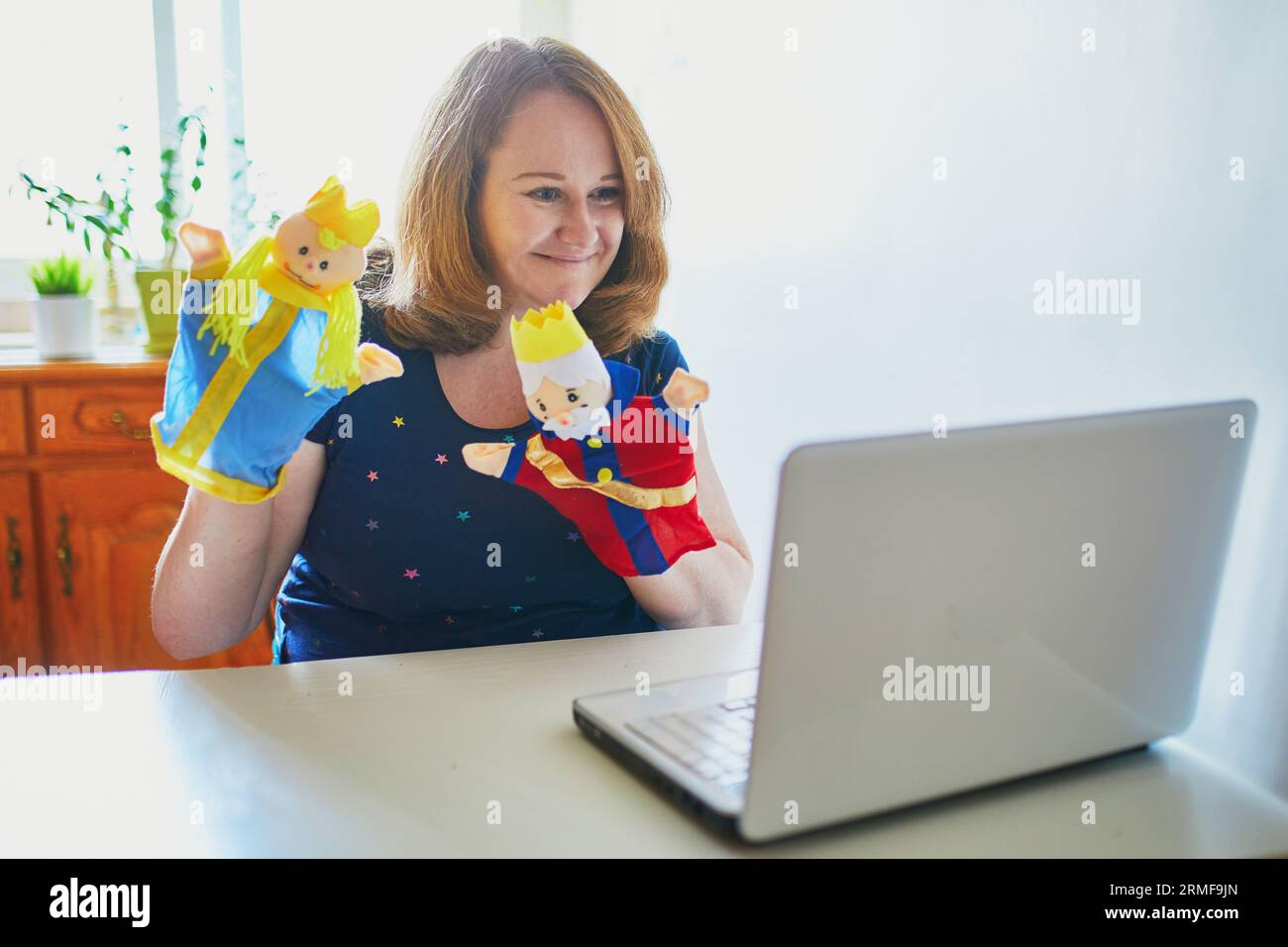 Kindergarten teacher in front of laptop having video conference chat ...