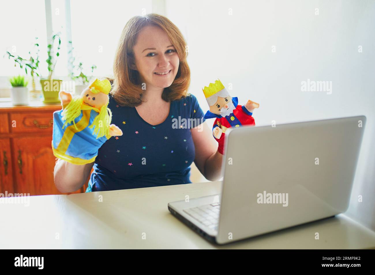 Kindergarten teacher in front of laptop having video conference chat ...