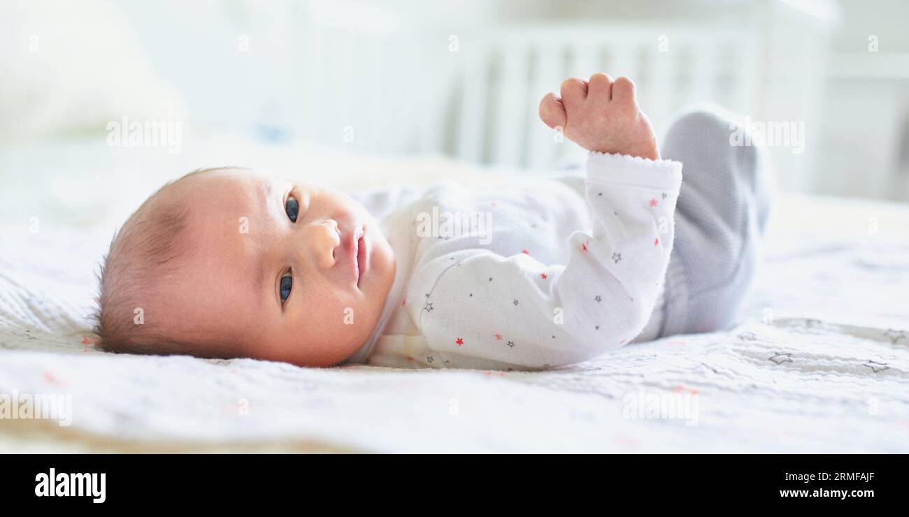 Adorable newborn baby girl lying on her parents' bed at home Stock Photo - Alamy