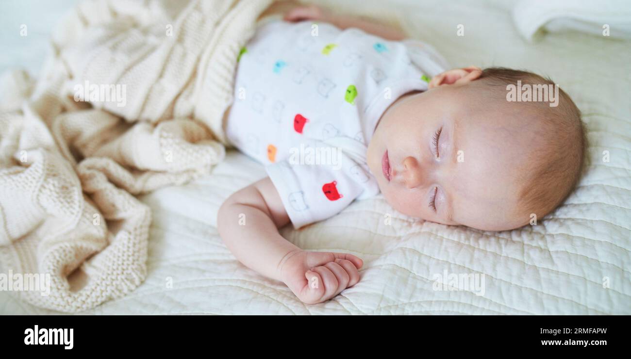 3 months old baby girl sleeping under knitted blanket. Child having a ...