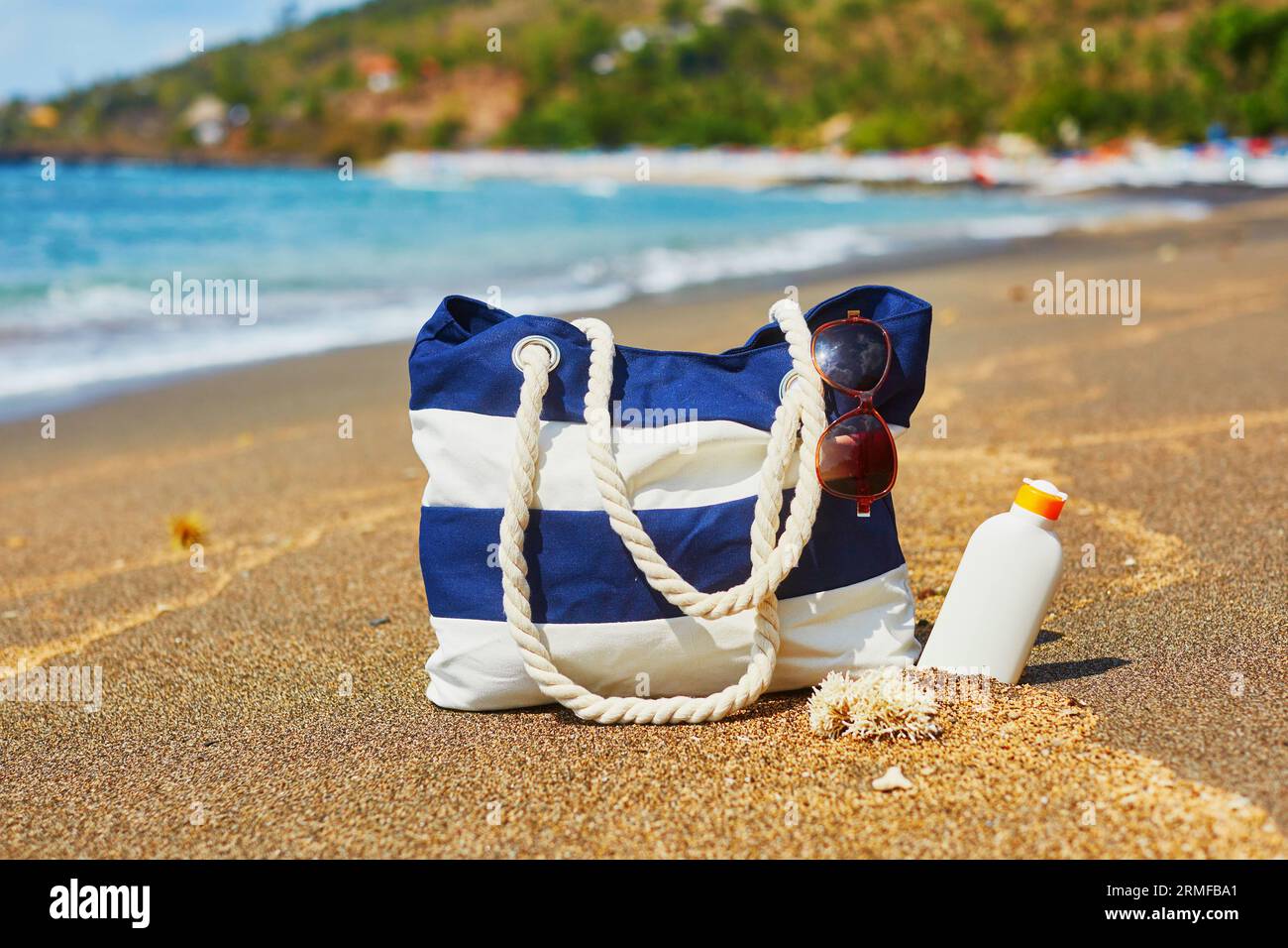 Beach bag, flip flops, sunscreen bottle and sunglasses on a Balinese ...
